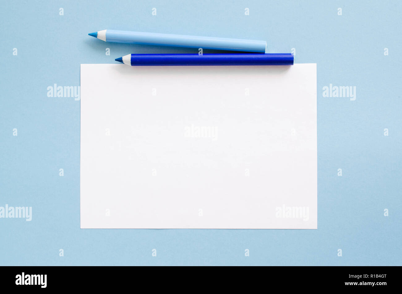 White blank sheet of paper and two blue pencils Stock Photo - Alamy