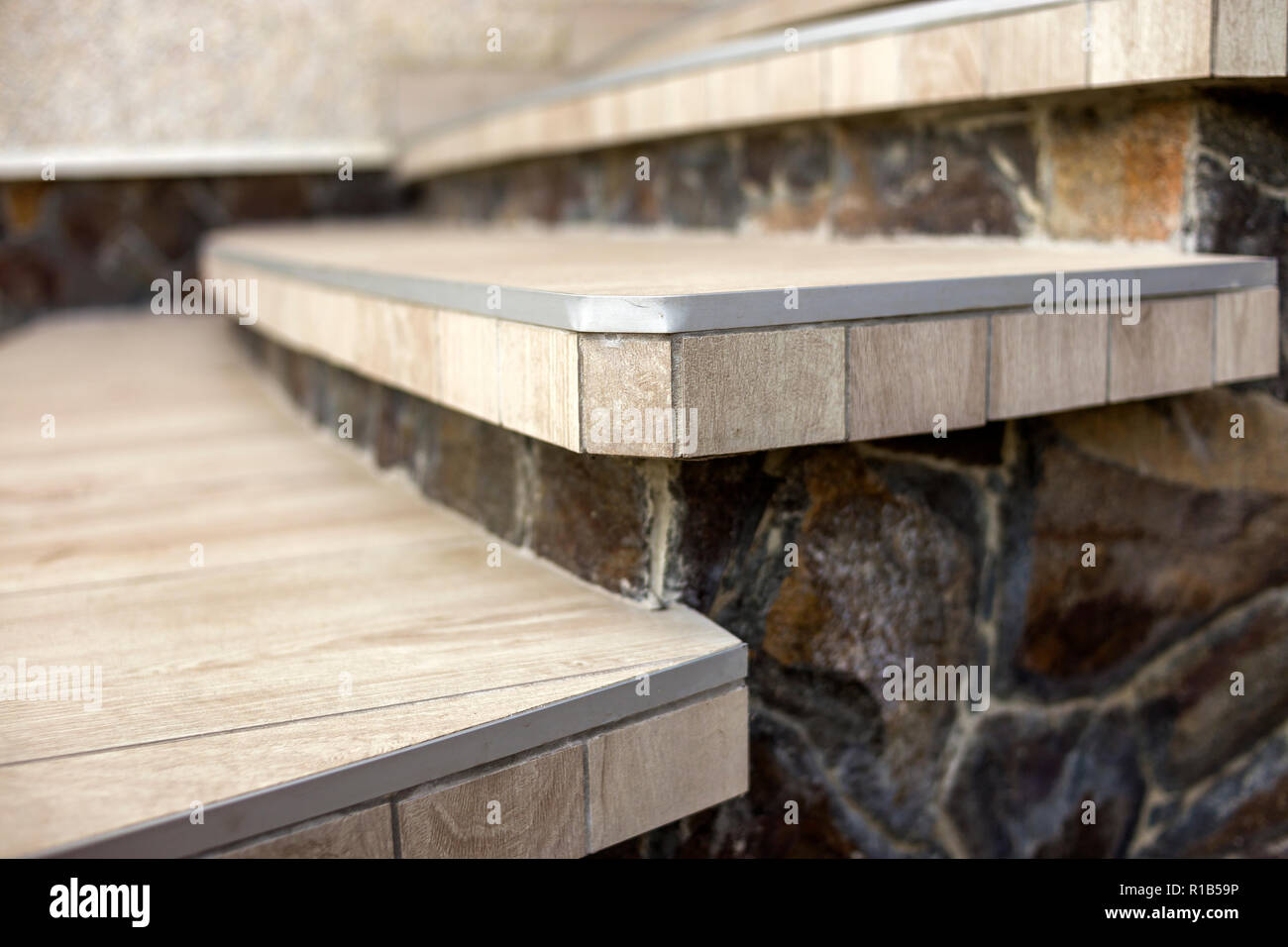 Side view of lit by sun new staircase with light tiles and decorated ...