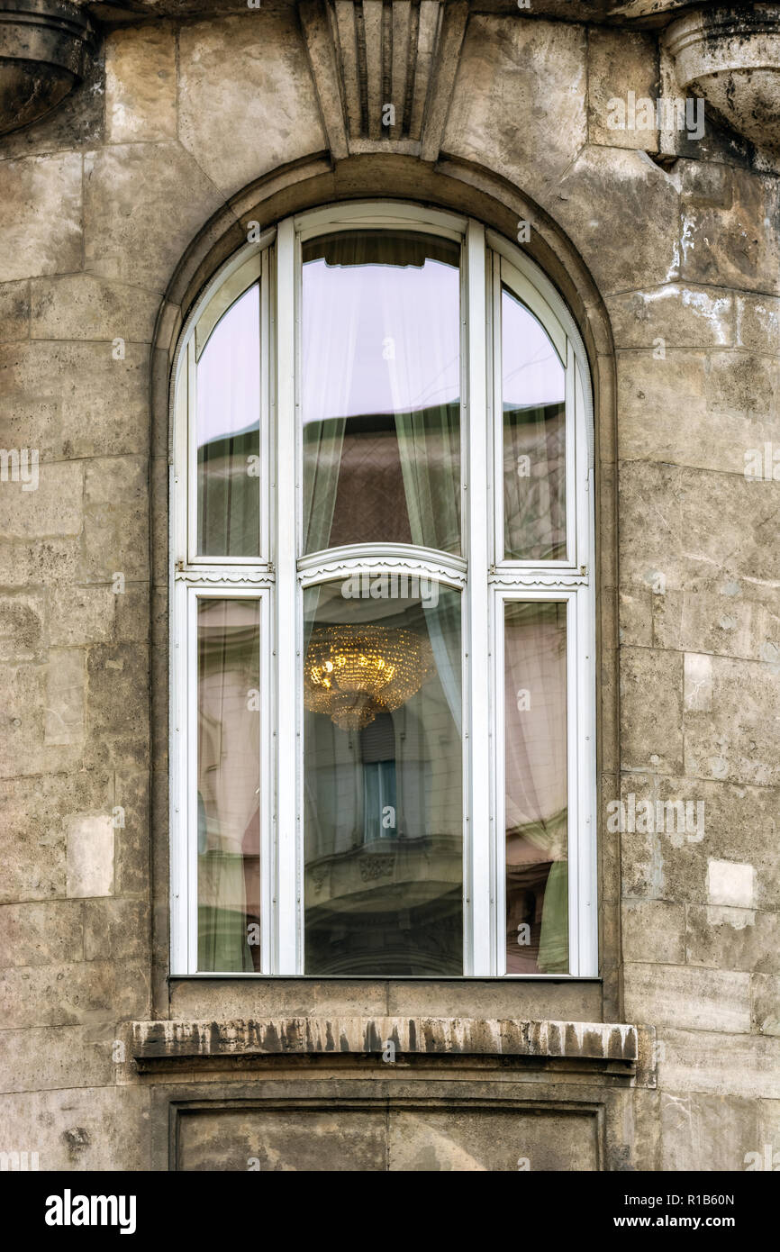 Window with arch and white frame against the stone wall of the old ...