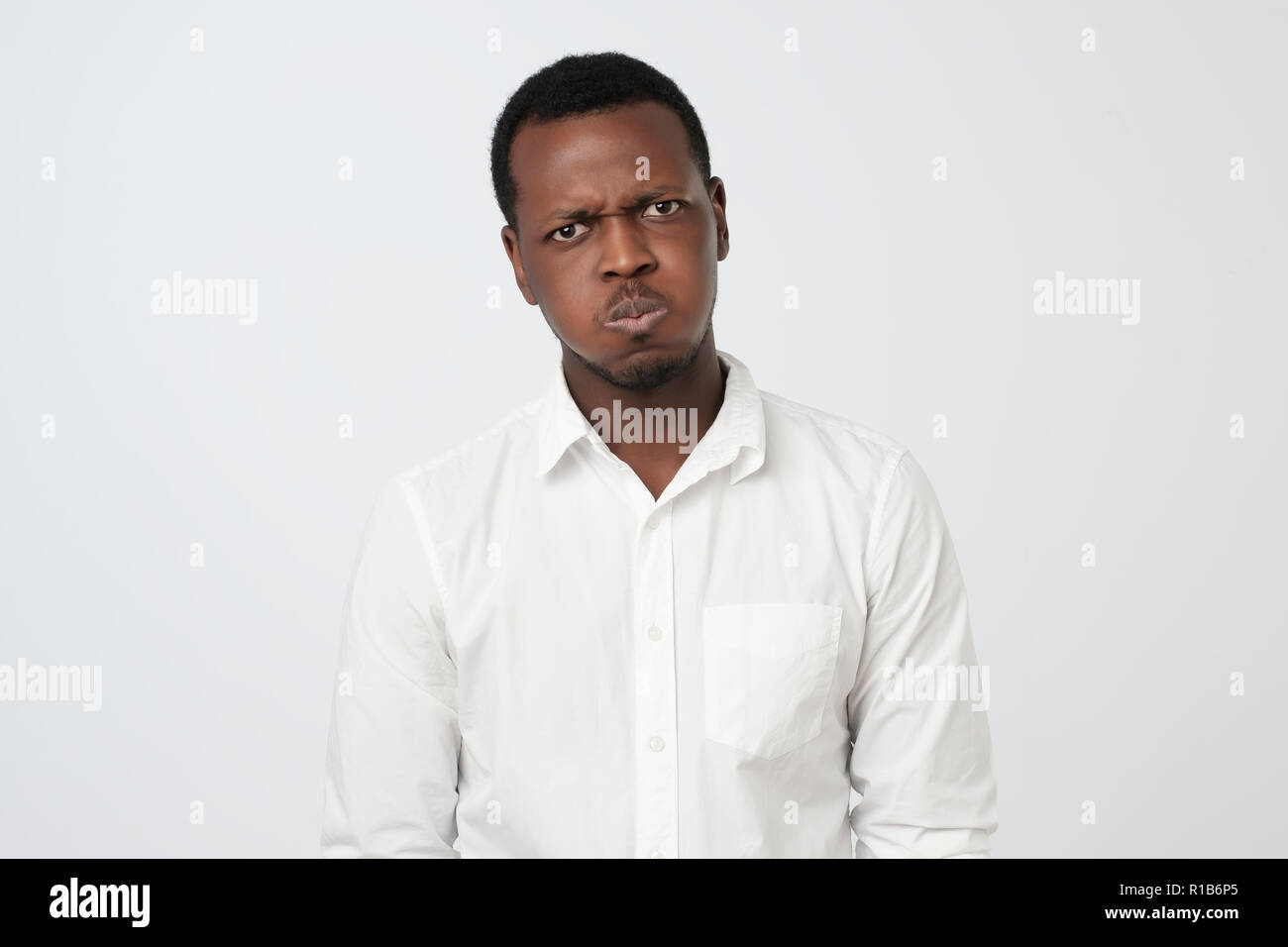 Young handsome african man blowing his cheeks while being offended at ...