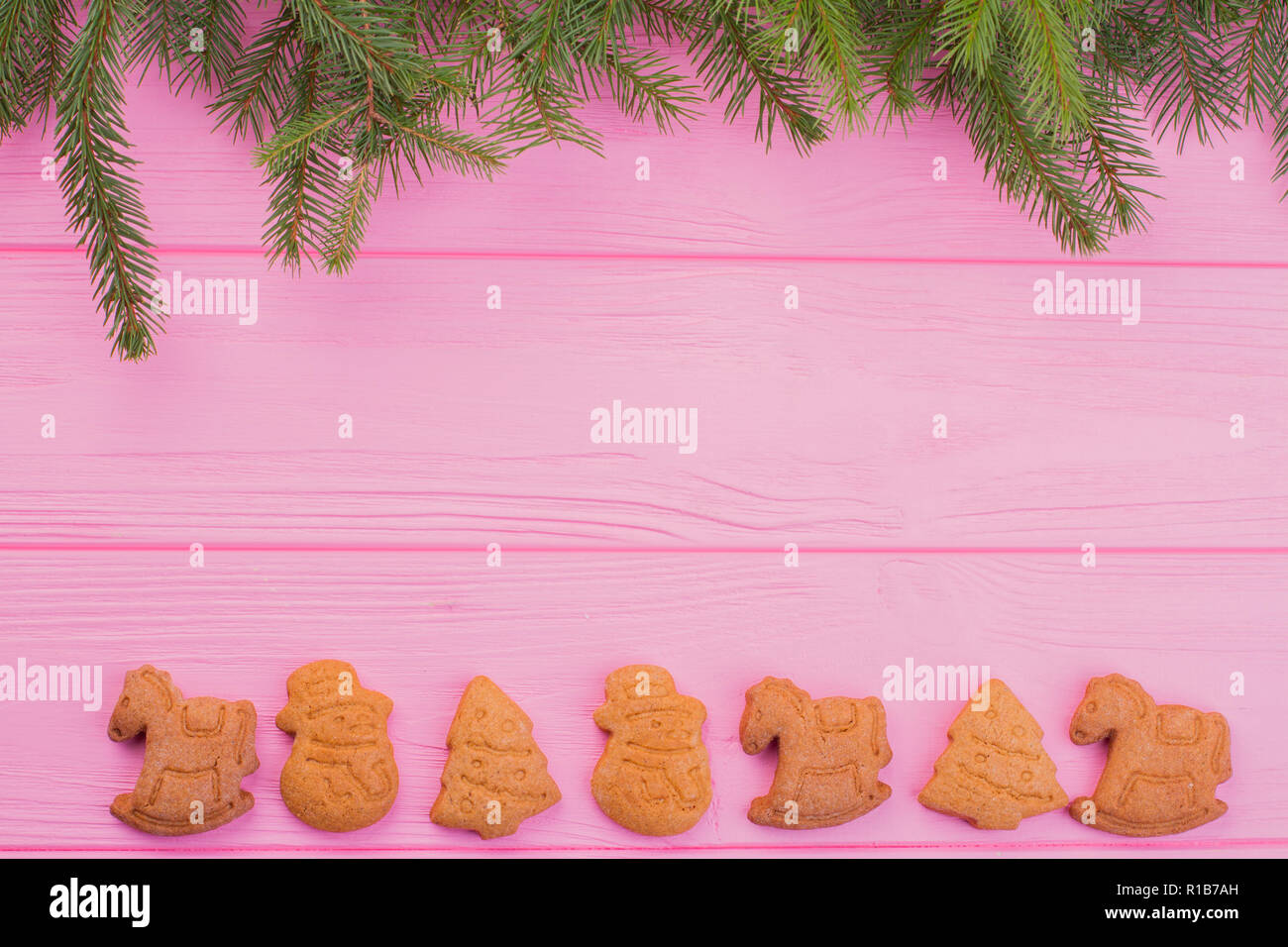 Pink background with spruce branches and gingerbread cookies Stock ...