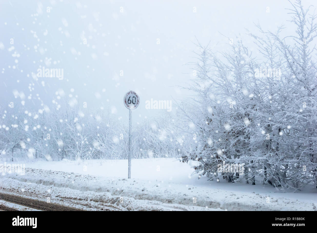 Speed limit traffic sign covered with ice on snowy winter background ...