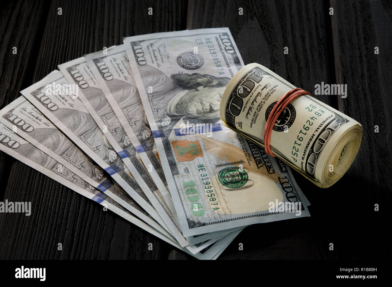 A thick roll of old hundred dollar banknotes tied a red rubber band ...