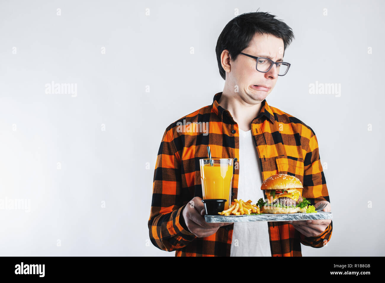 Handsome man refusing unhealthy burger against white background. Diet ...