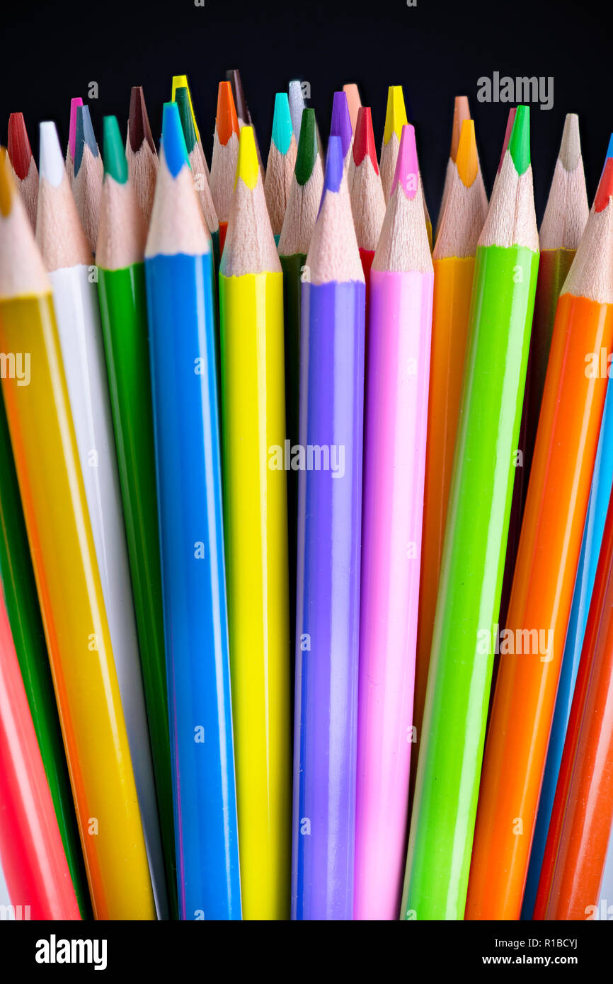 vertical image of new colored pencils vibrant and bright, on a black ...