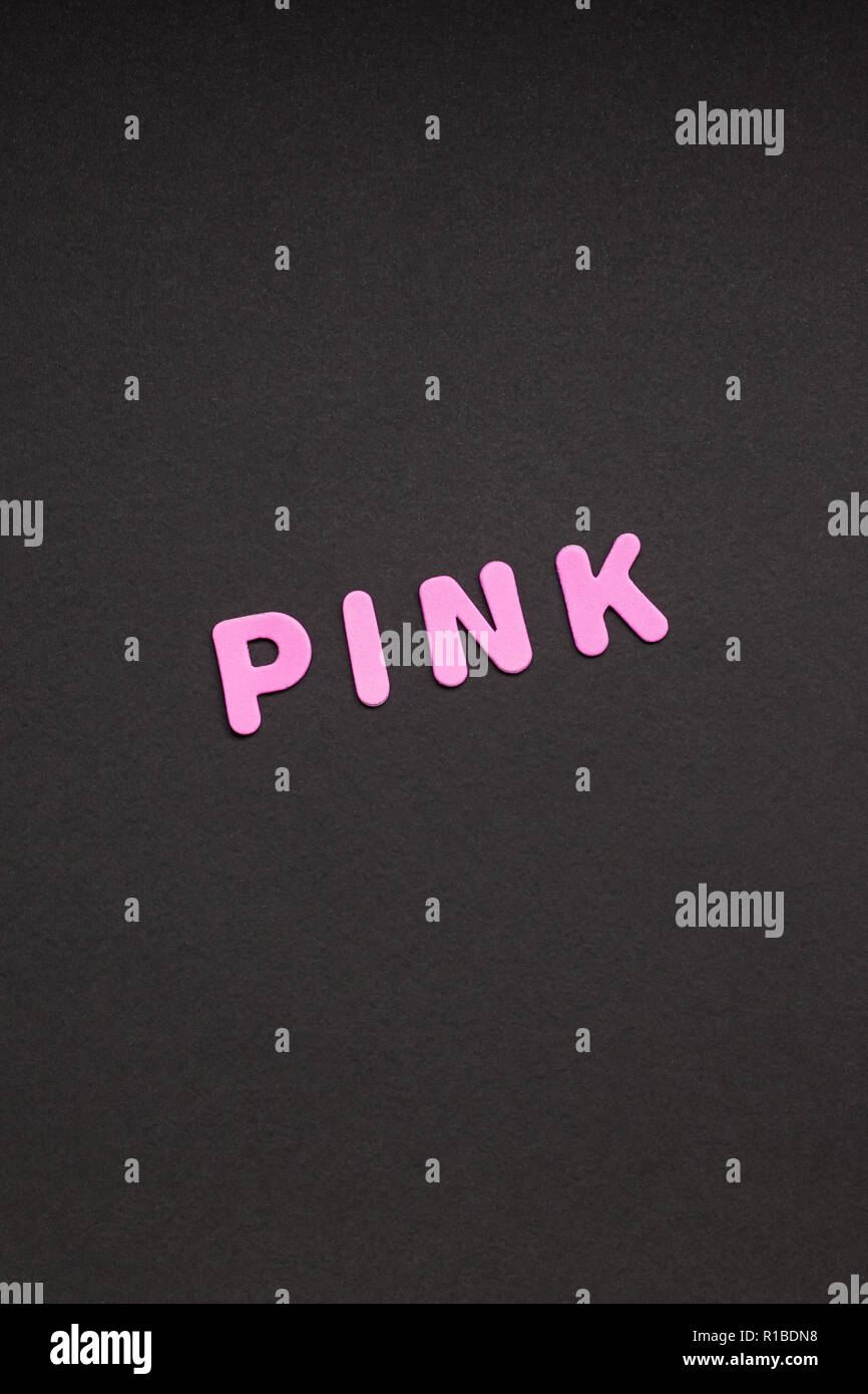 Creative colorful text made from plastic letters pink writing on black ...
