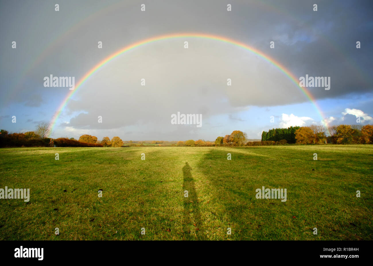 Shadow under double rainbow at the end of a wet and windy day in East ...