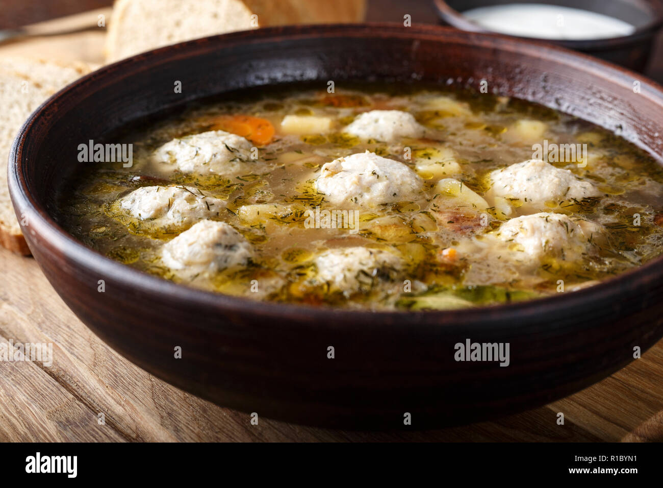 rustic home made soup with meatballs on a simple wooden background ...