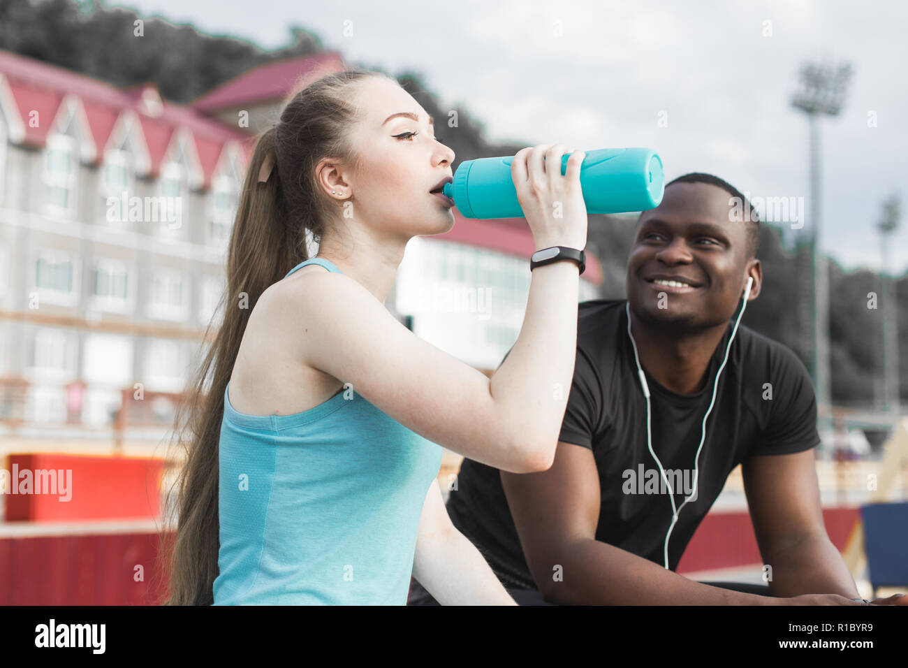 Group of athletes sitting on the bench and resting after hard street ...
