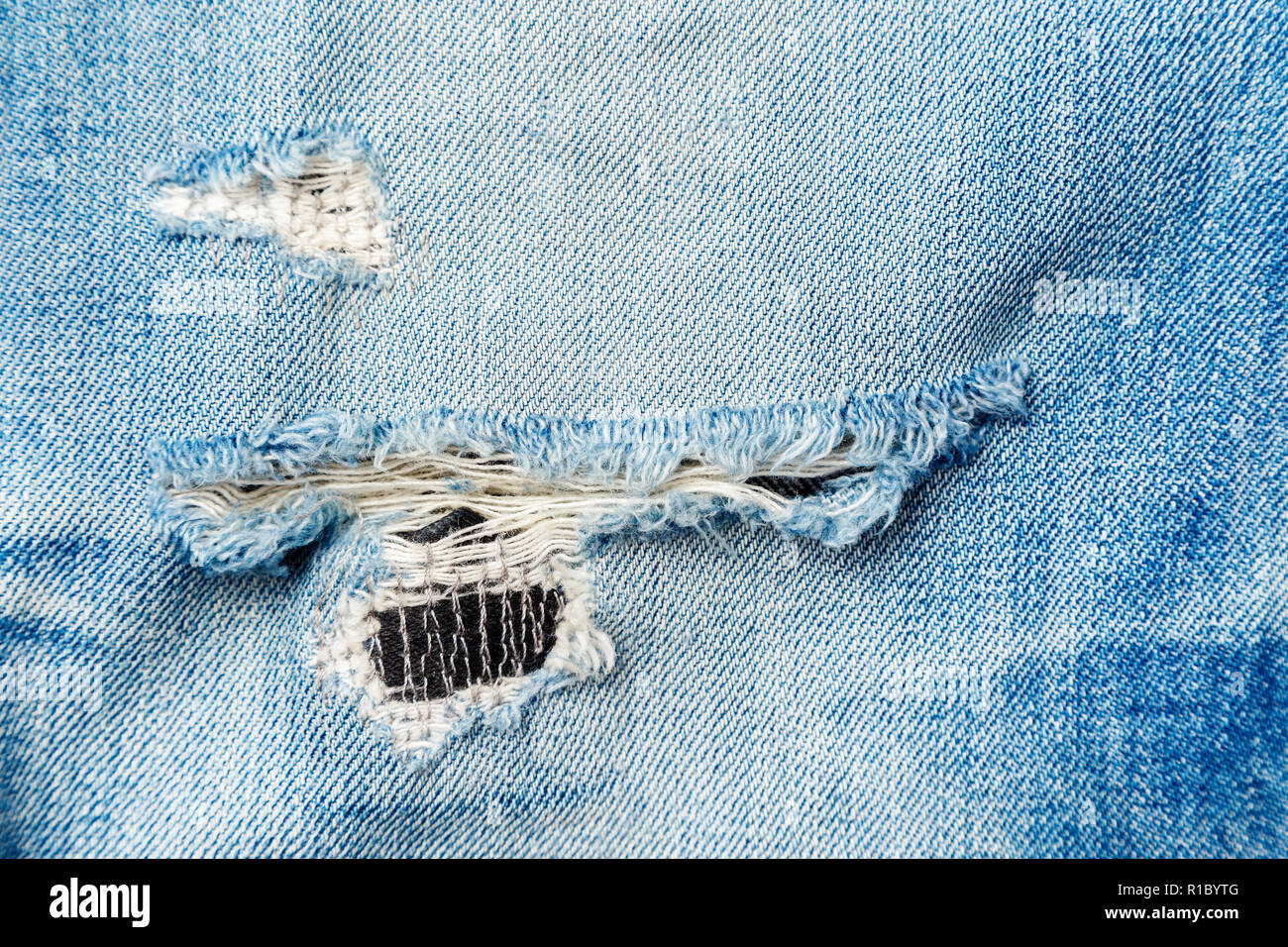 blue ragged denim background. well visible texture of the fabric. place ...