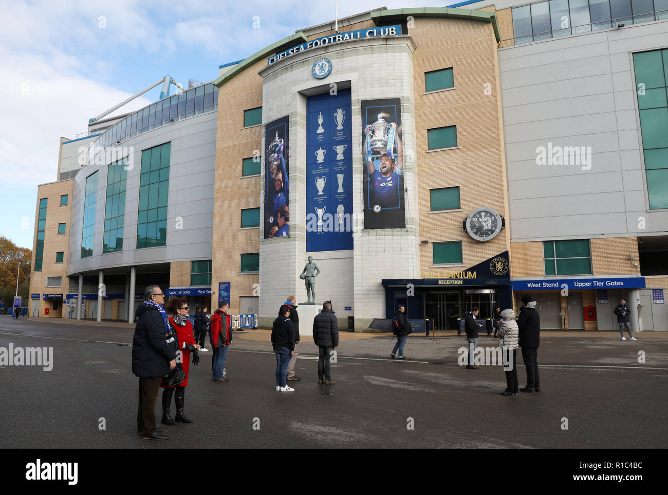Fans outside Stamford Bridge observe a minute's silence to mark the ...