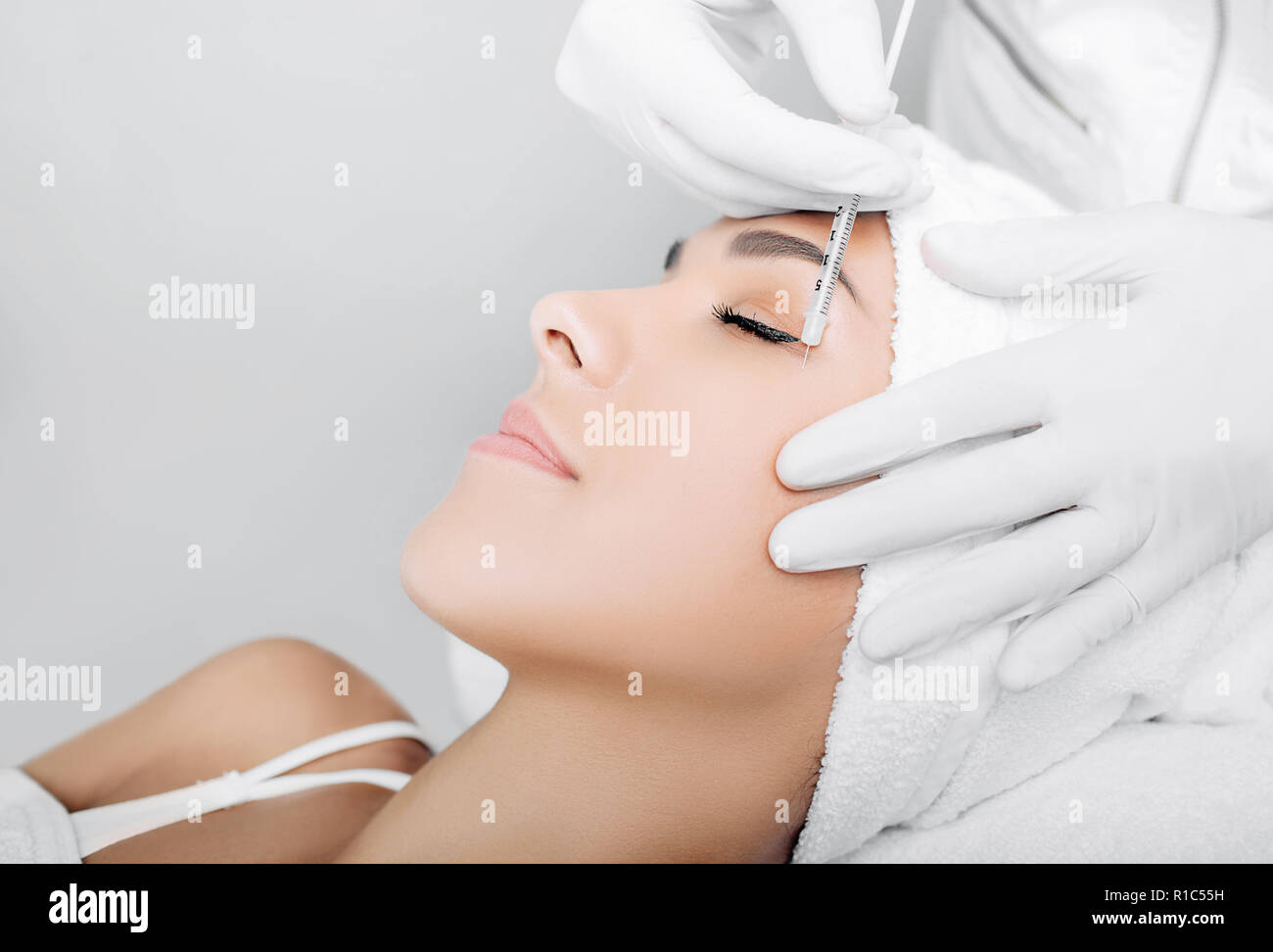 Beautiful woman having facial injection into area near eye. Anti age ...