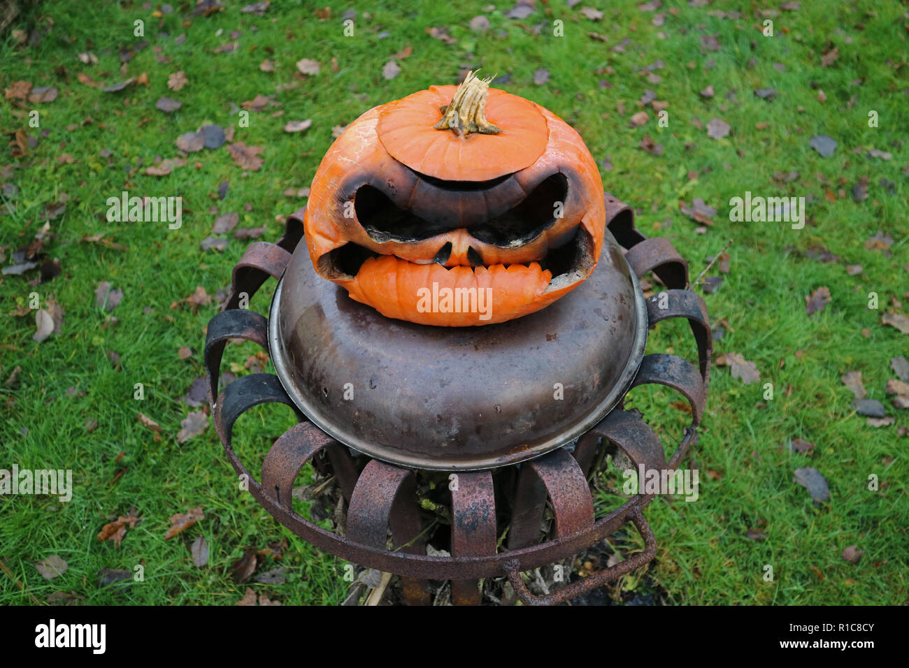 old burnt halloween pumpkin on fire basket Stock Photo - Alamy