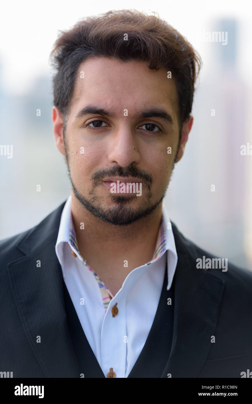 Face of young handsome Indian businessman outdoors Stock Photo - Alamy