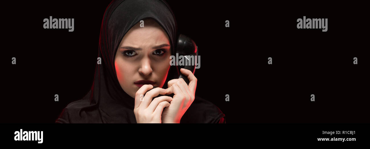 Portrait of beautiful serious scared young muslim woman wearing black ...