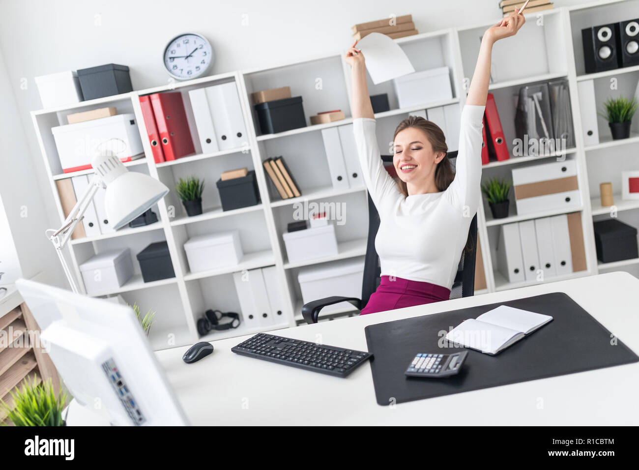 The young girl leaned back in her chair and put her hands up Stock ...