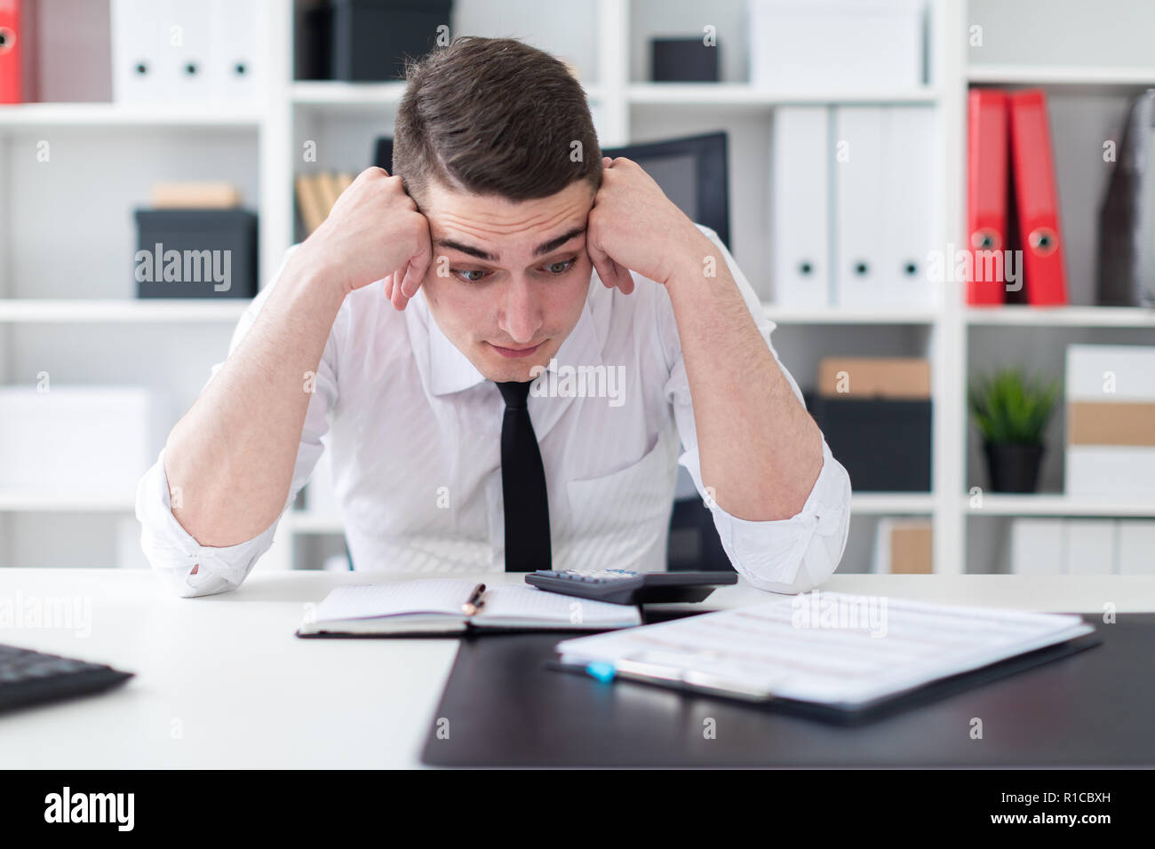 A young man sitting at a computer Desk in the office and propped his ... A young man sitting at a computer Desk in the office and propped his ...