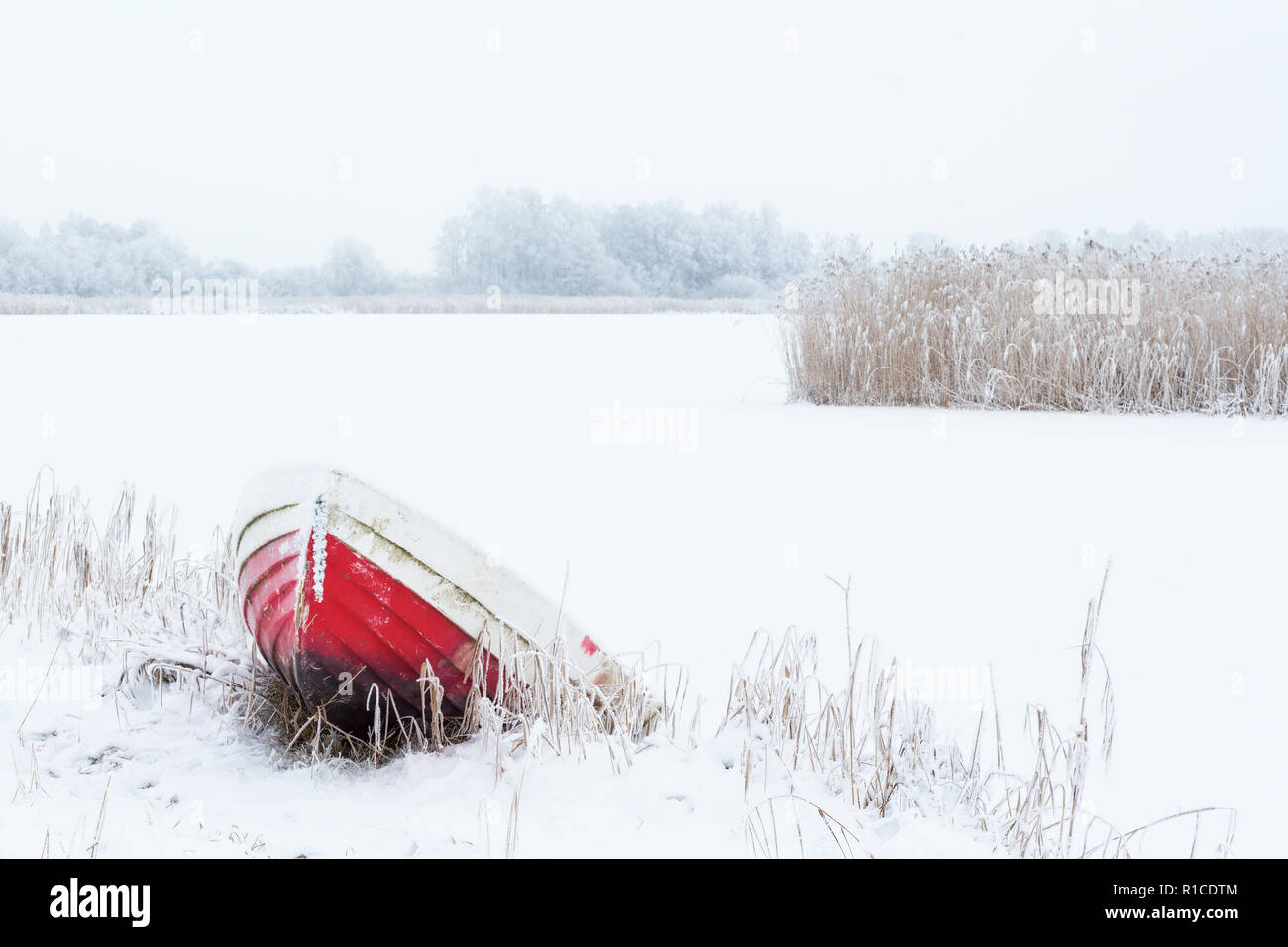 Wintry lake landscape with a boat on the beach Stock Photo - Alamy