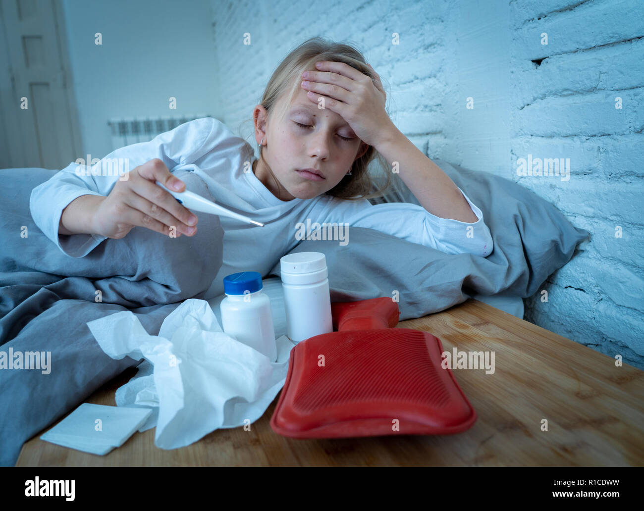 Cute sick girl in pain with high fever and headache feeling ill lying ...