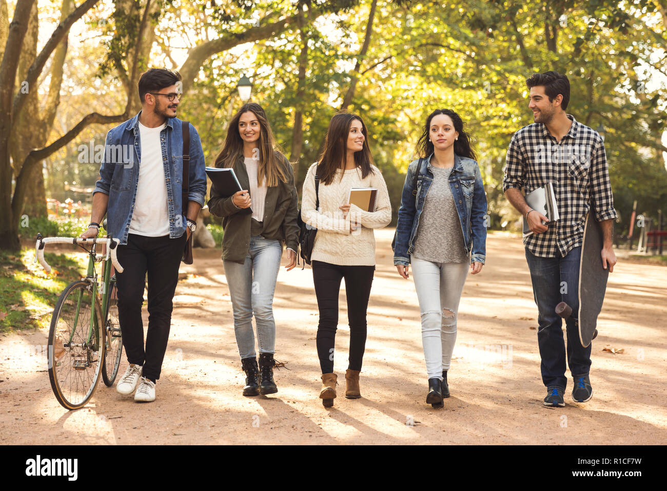 Group of students walking together in the park Stock Photo - Alamy