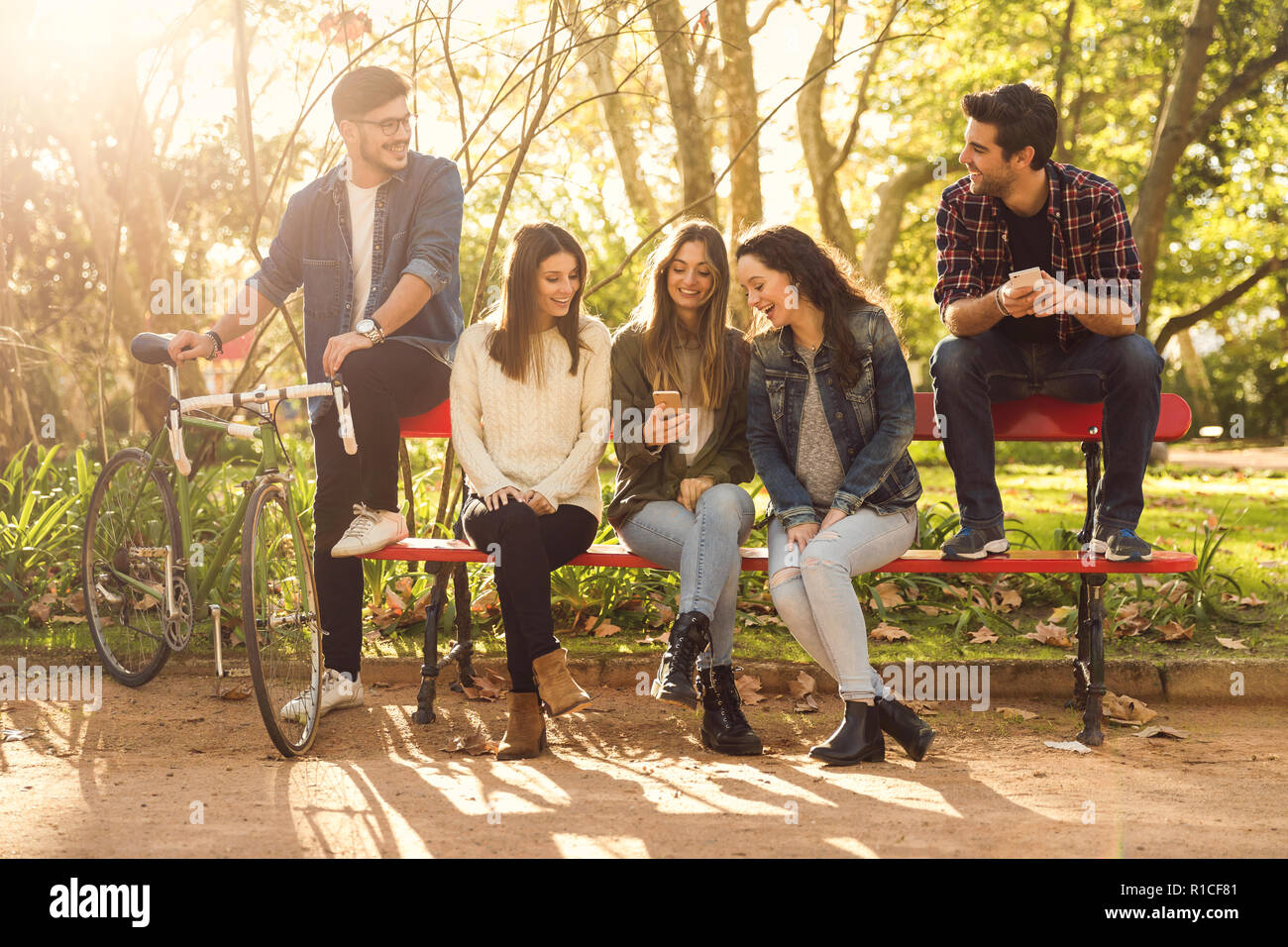 Group of friends sitting bench hi-res stock photography and images - Alamy