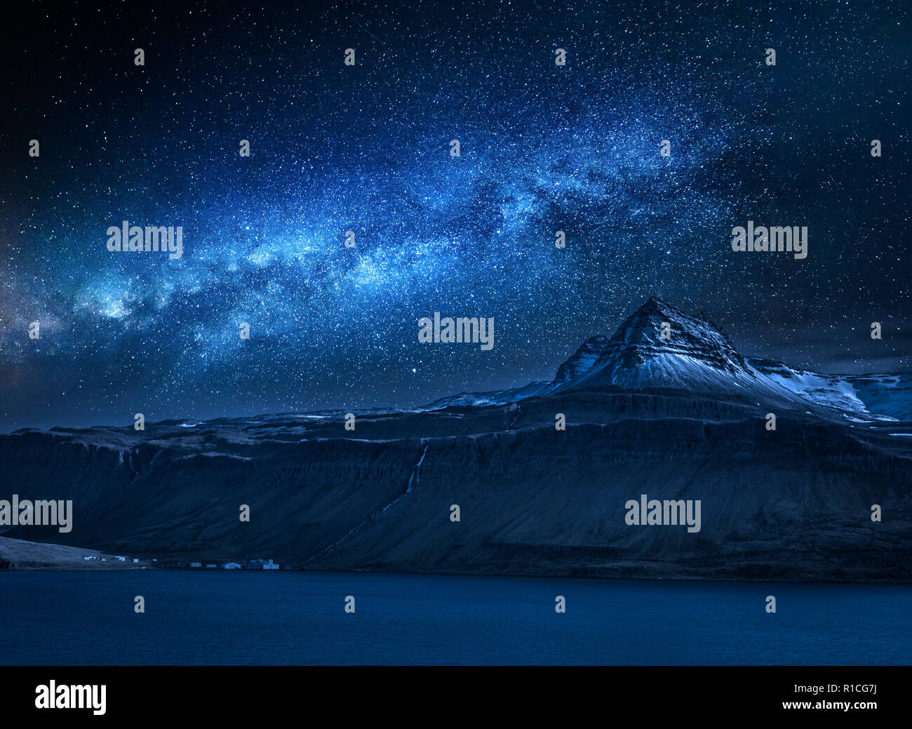 Milky way over volcanic mountain over fjord at night, Iceland Stock ...