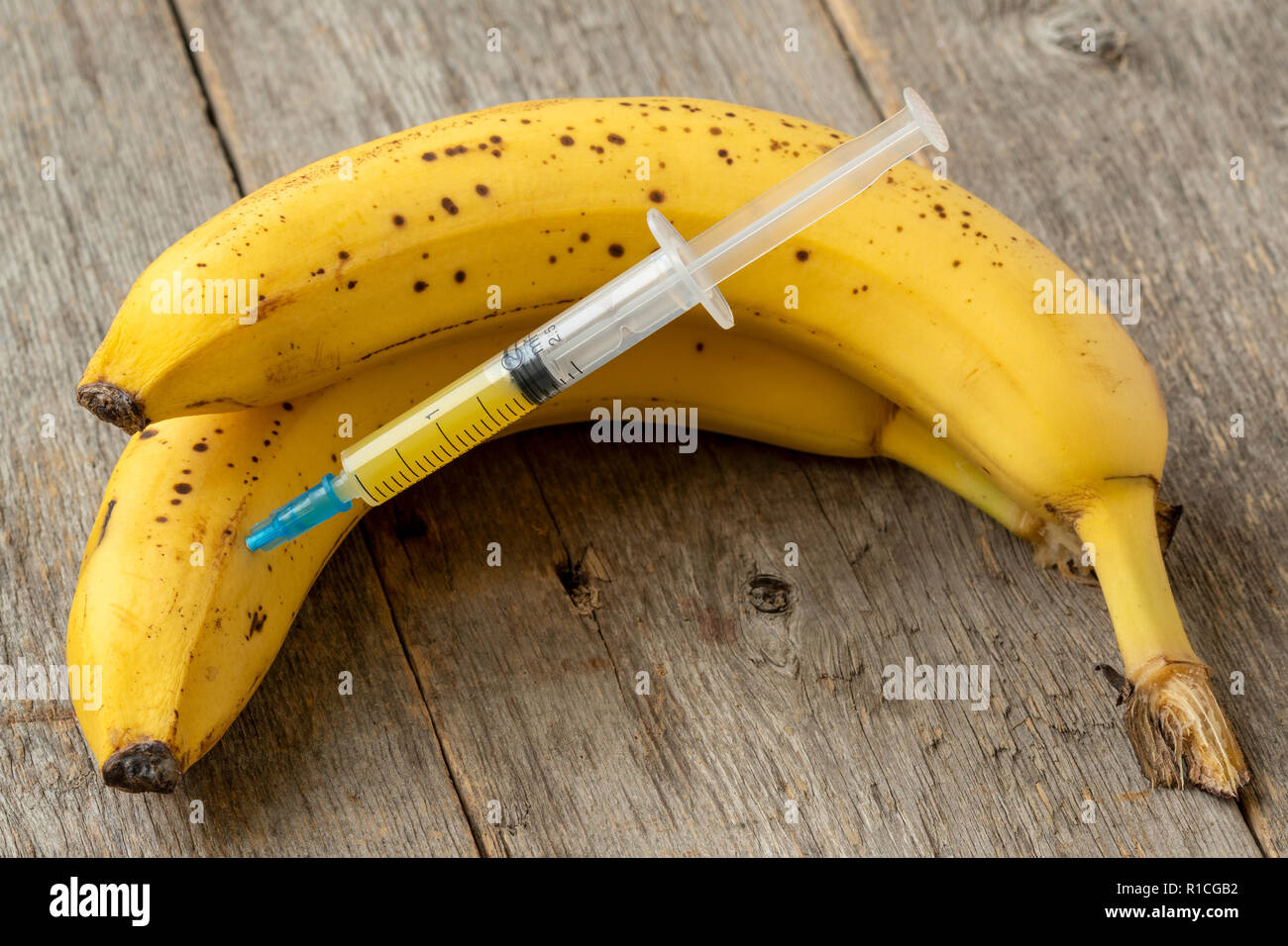 Syringe and banana bunch. Concept for genetically modified food and ...
