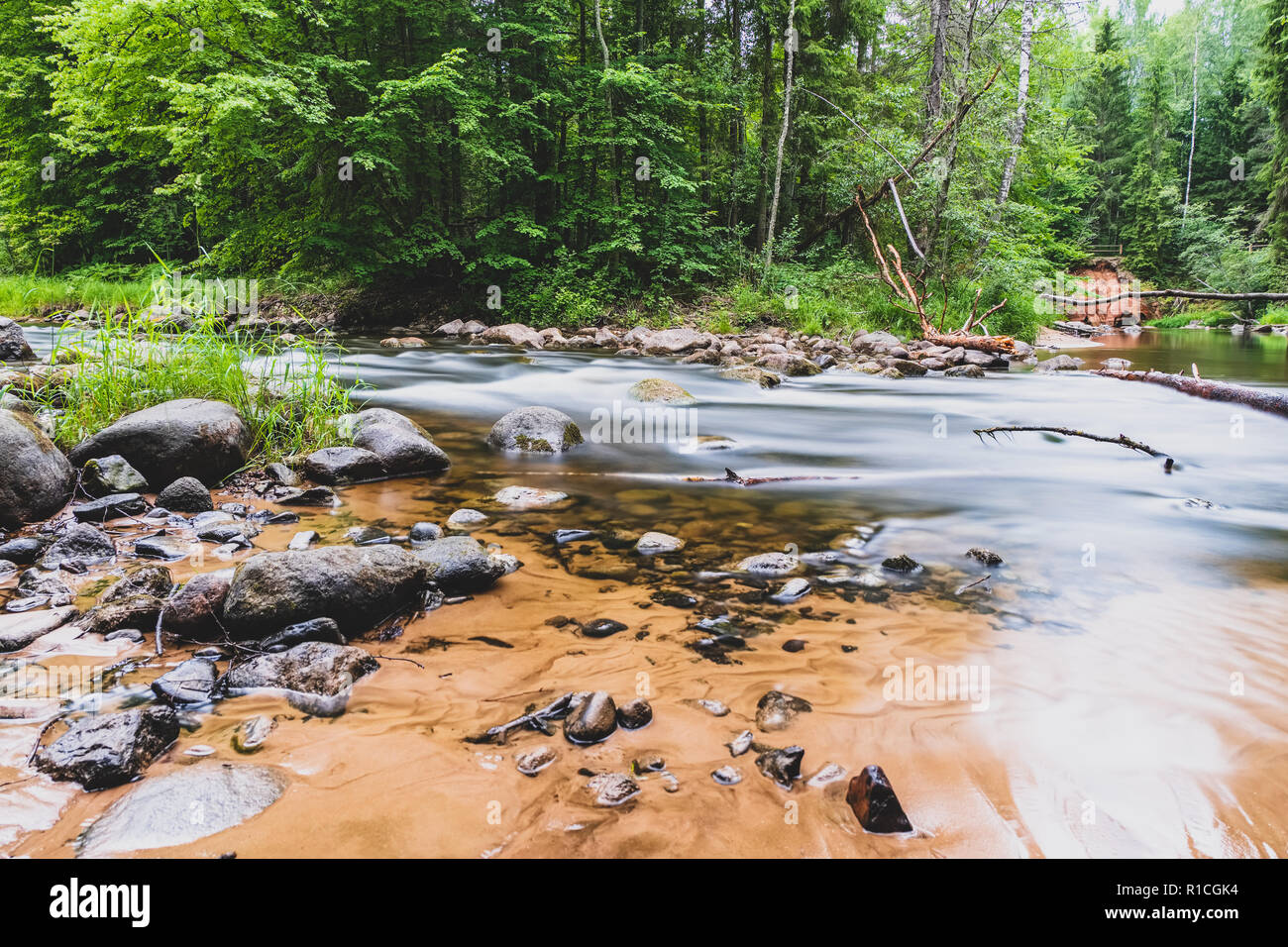 long exposure rocky mountain river in summer with high water stream ...