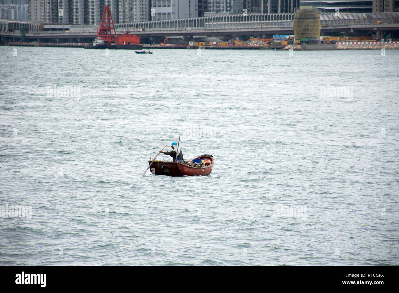 Chinese people paddle and floating wooden boat in the sea for catch ...