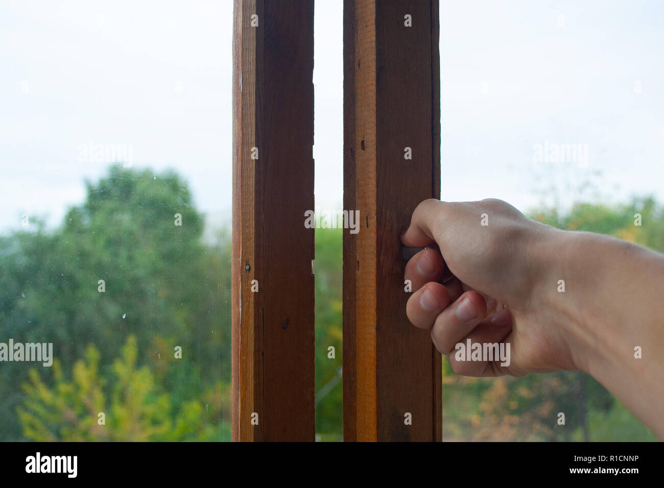 Hand closing the window at cold weather. Winter is coming, close window ...