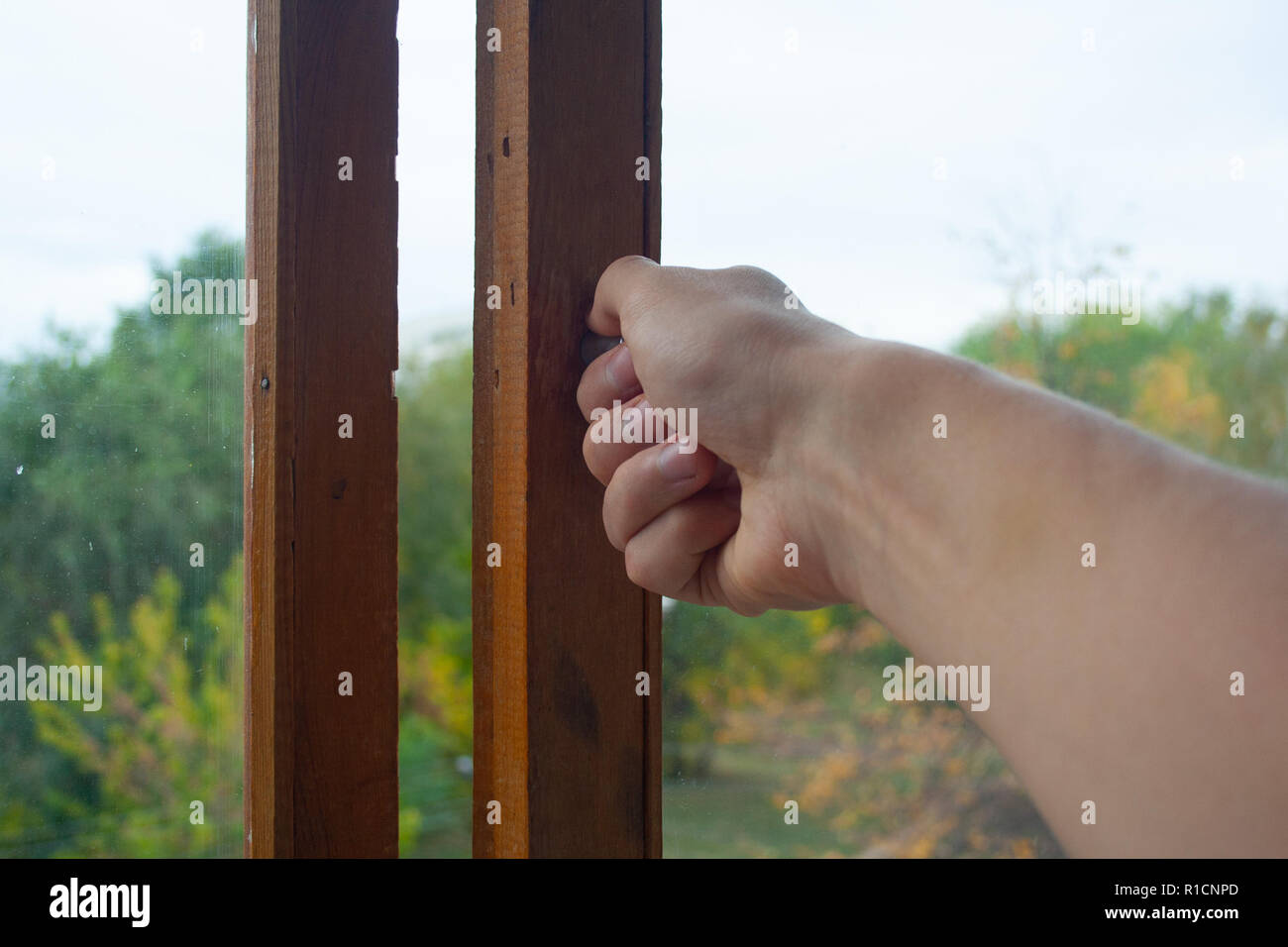 Hand closing the window at cold weather. Winter is coming, close window ...