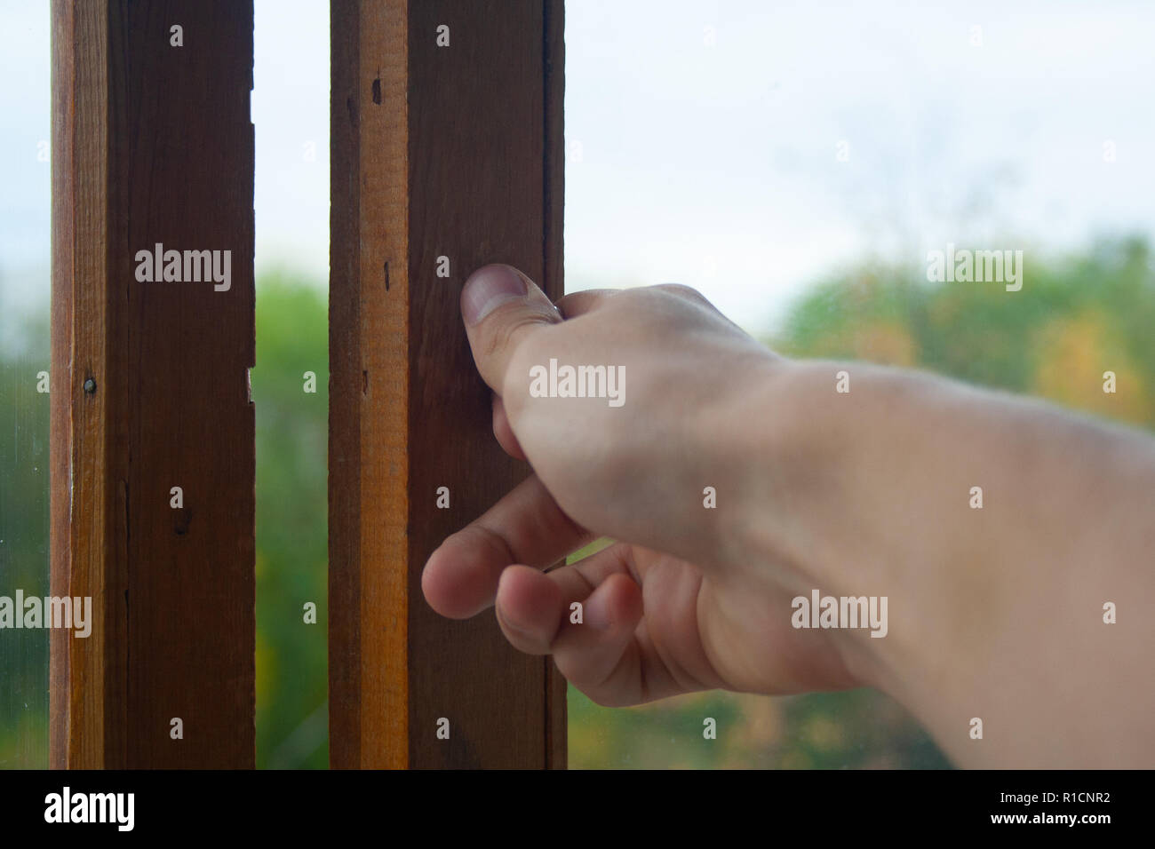 Hand closing the window at cold weather. Winter is coming, close window ...