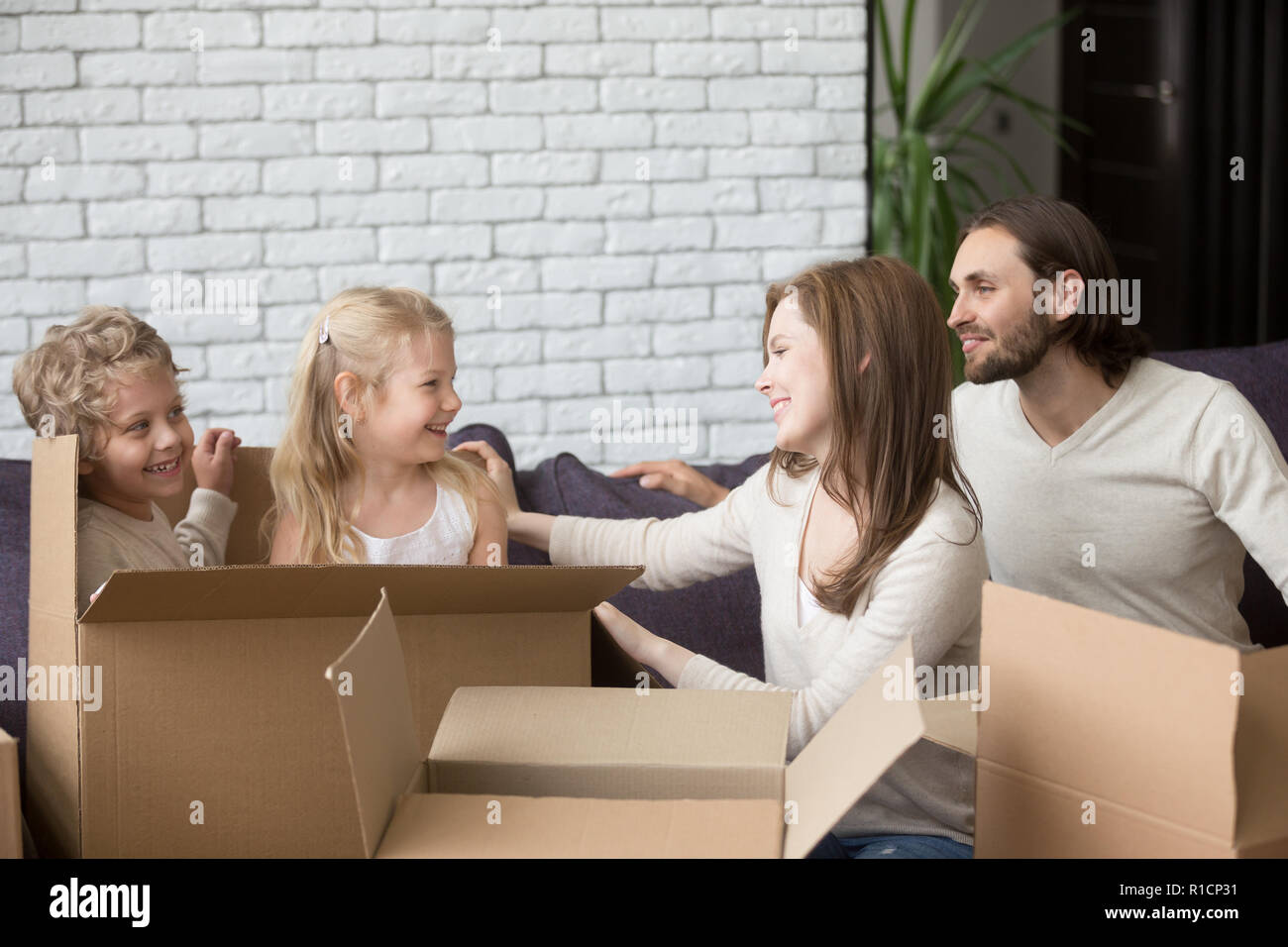Happy family with cardboard boxes at their new home Stock Photo - Alamy