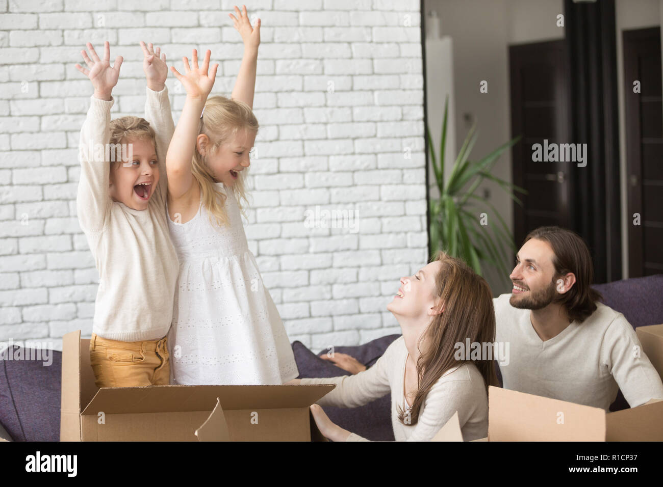 Happy family with cardboard boxes at their new home Stock Photo - Alamy