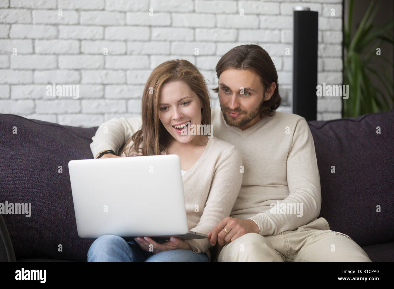 Married couple using computer buying via internet Stock Photo - Alamy