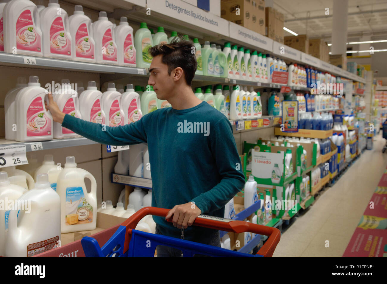 a customer picking up a bottle of Carrefour detergent Stock Photo - Alamy