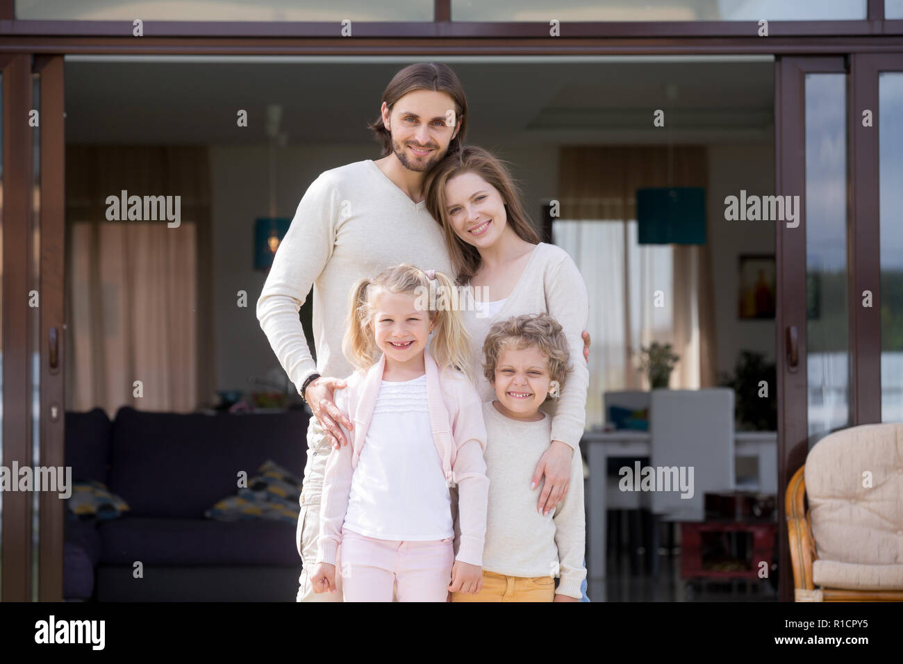 Family with children standing on terrace of new house Stock Photo - Alamy