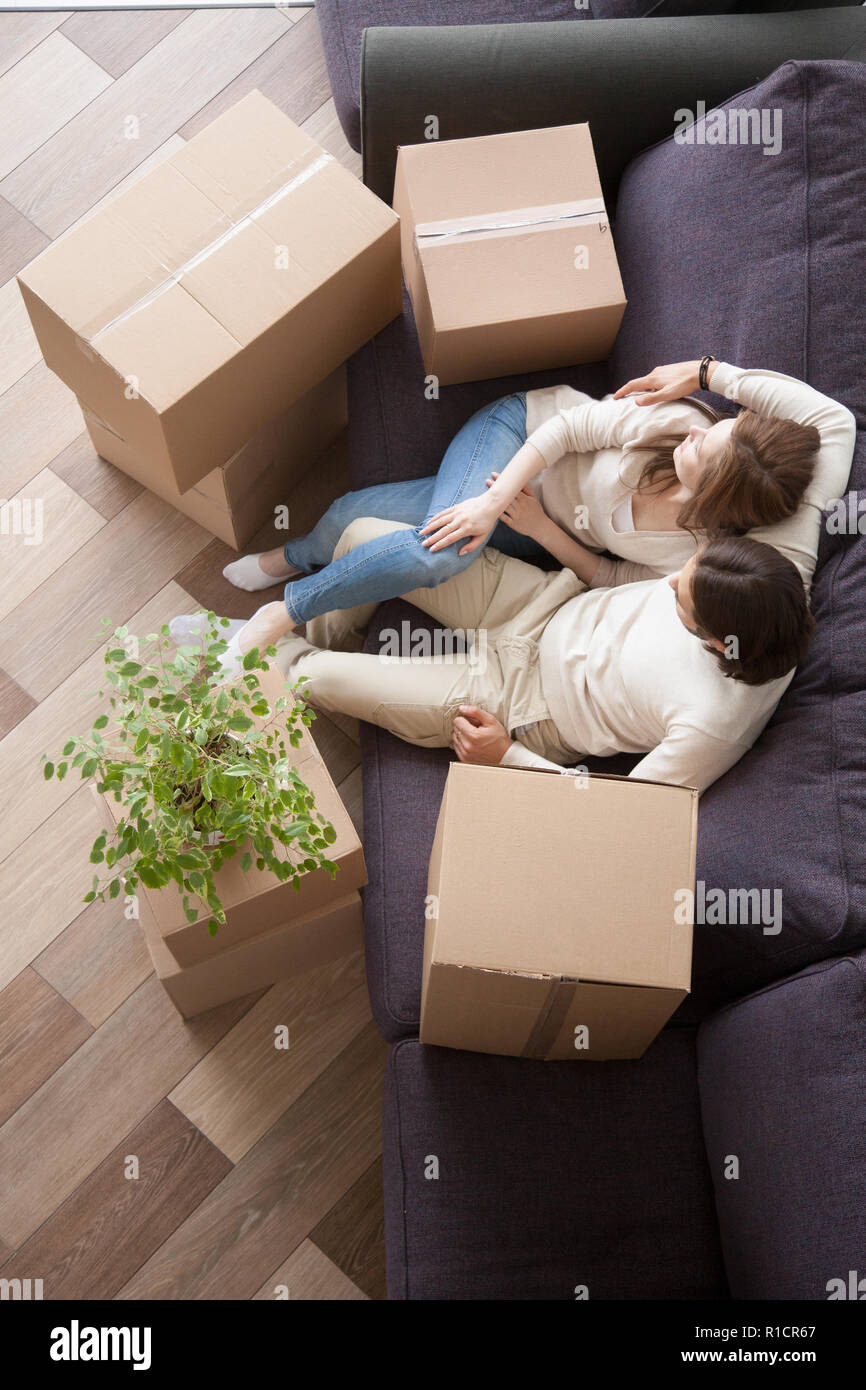 Couple sitting on couch in living room with unopened stuff Stock Photo ...
