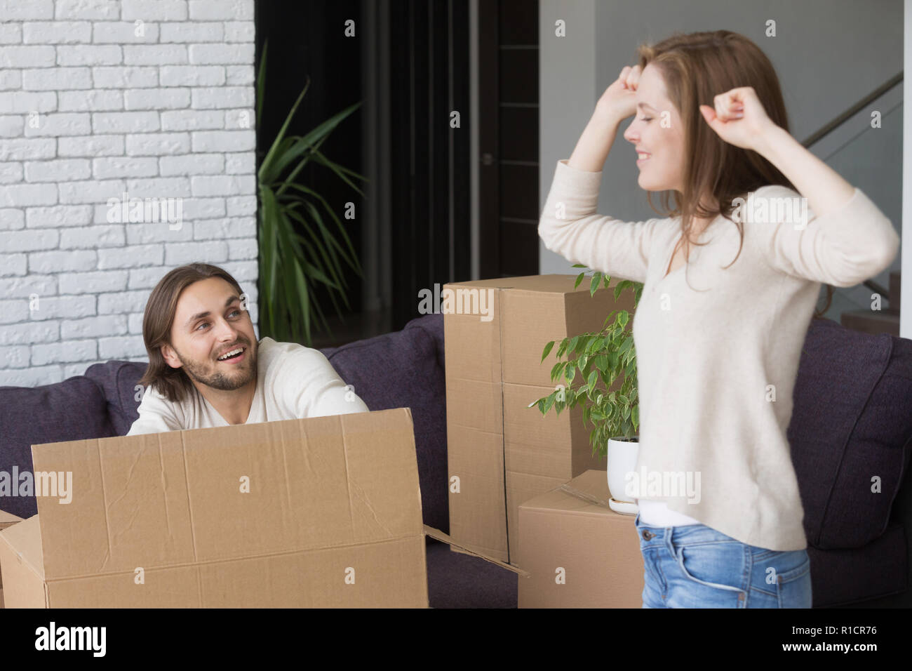 Married couple sitting on couch with unopened cardboard boxes Stock ...