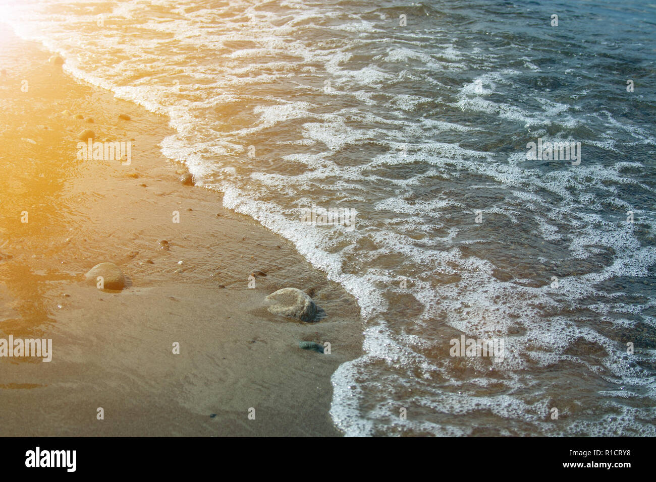 Stone beach with waves. Multi colore stones on beach Stock Photo - Alamy