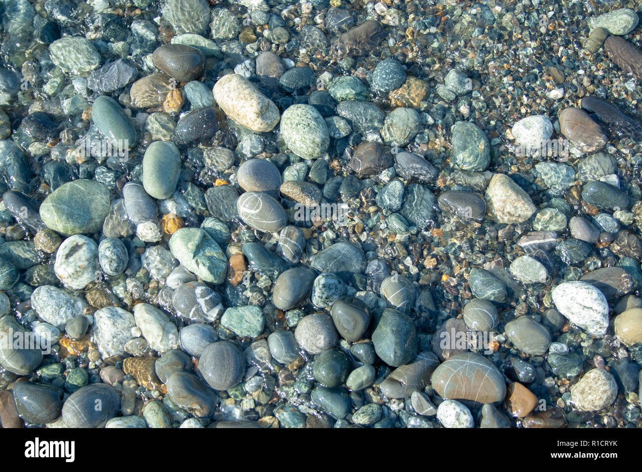 Stone beach with waves. Multi colore stones on beach Stock Photo - Alamy