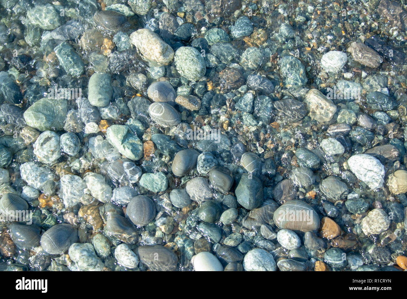 Stone beach with waves. Multi colore stones on beach Stock Photo - Alamy