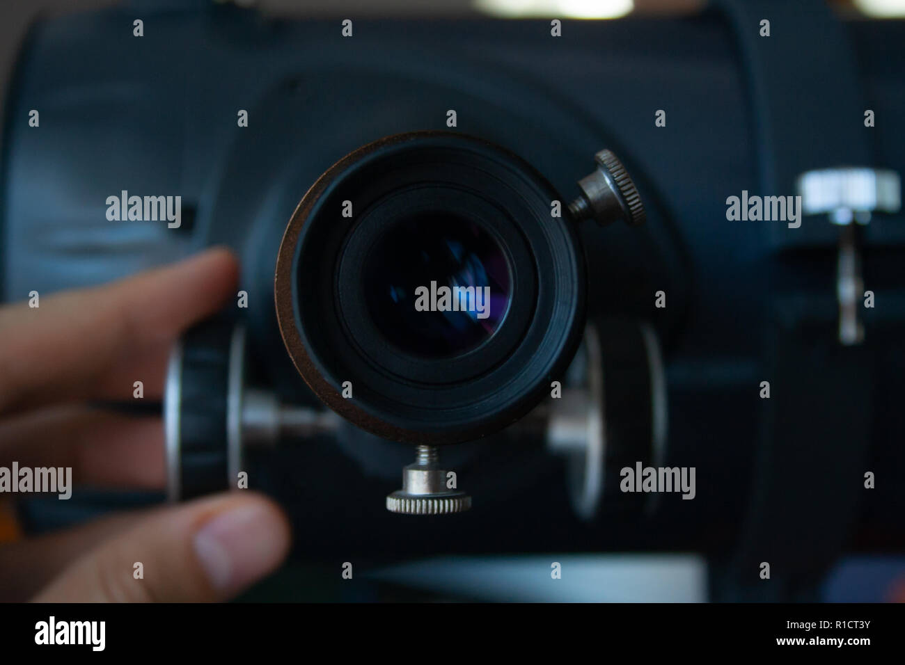 Close up of eyepiece of telescope with man's hand. Telescope tuning ...