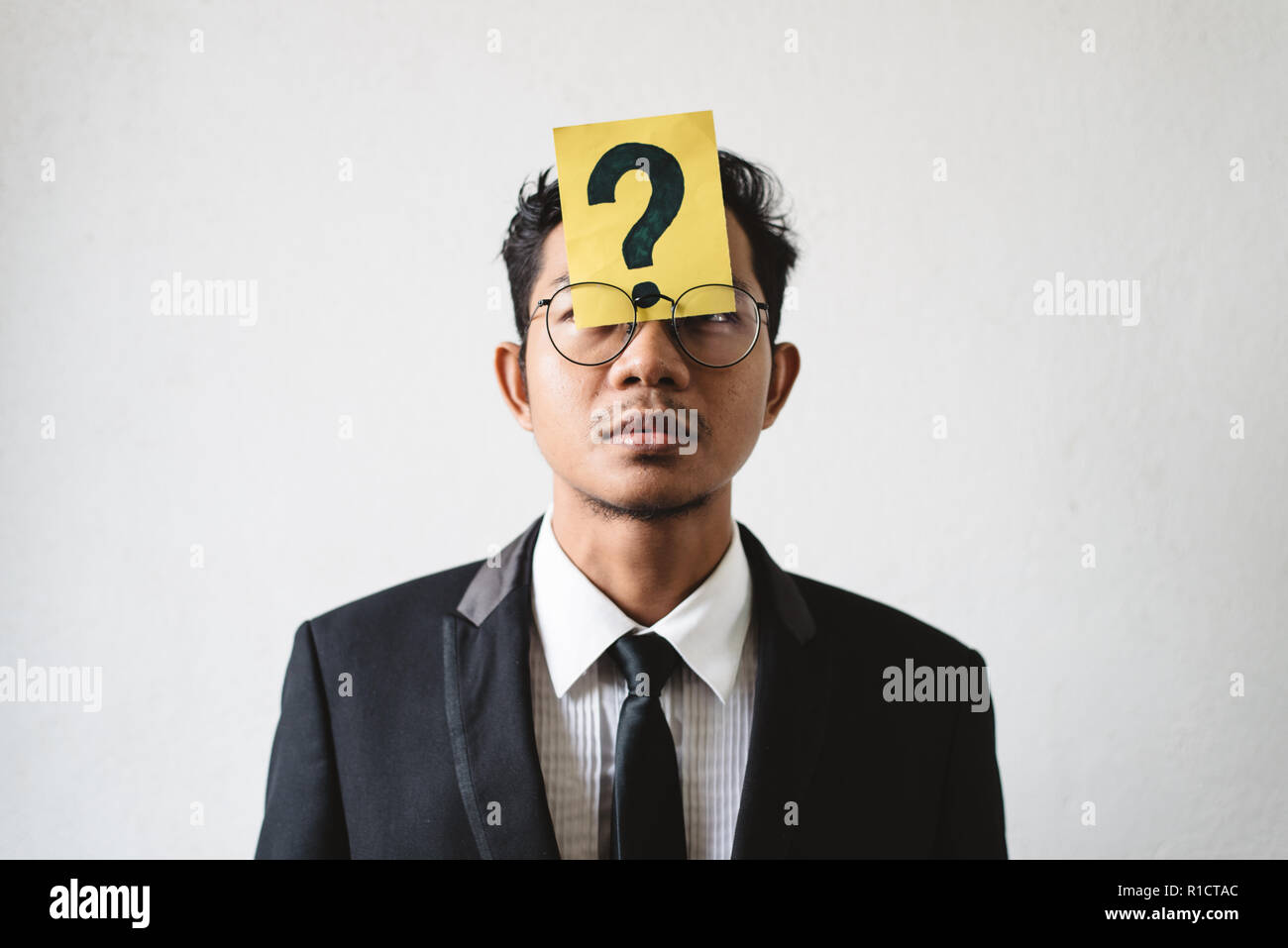 Young Asian businessman with QUESTION MARK on his forehead. Concept of ...
