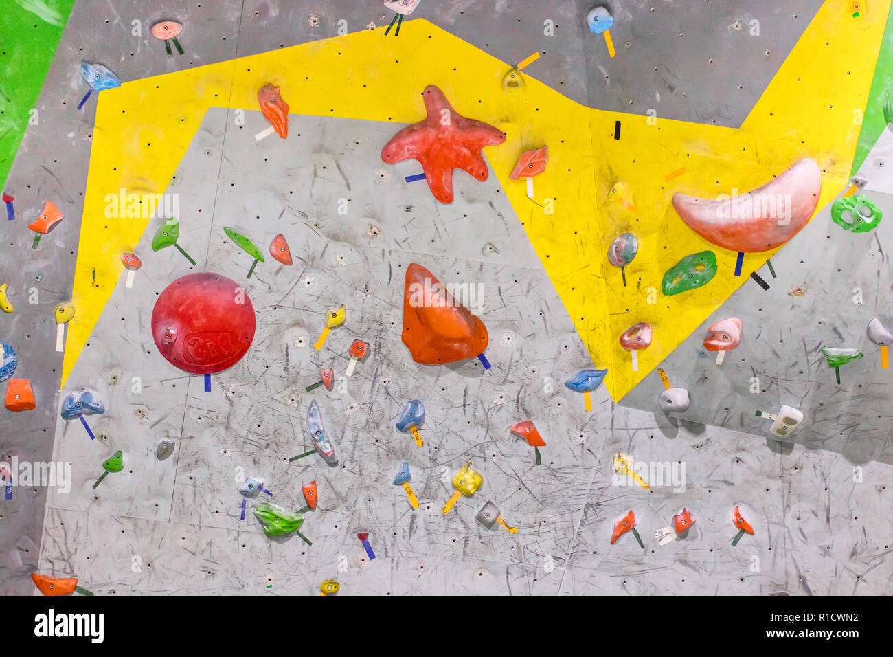 Climbing wall in the boulder hall with colored hooks Stock Photo - Alamy