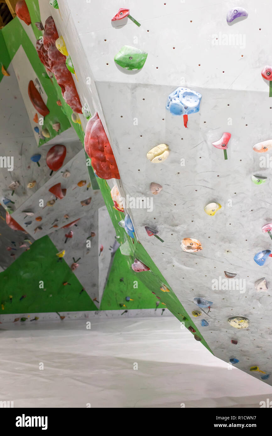 Climbing wall in the boulder hall with colored hooks Stock Photo - Alamy