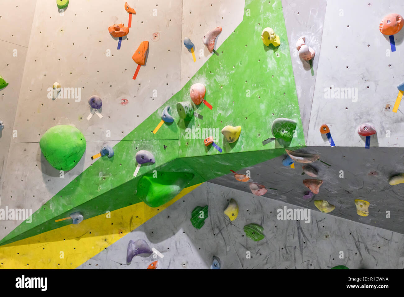 Climbing wall in the boulder hall with colored hooks Stock Photo - Alamy