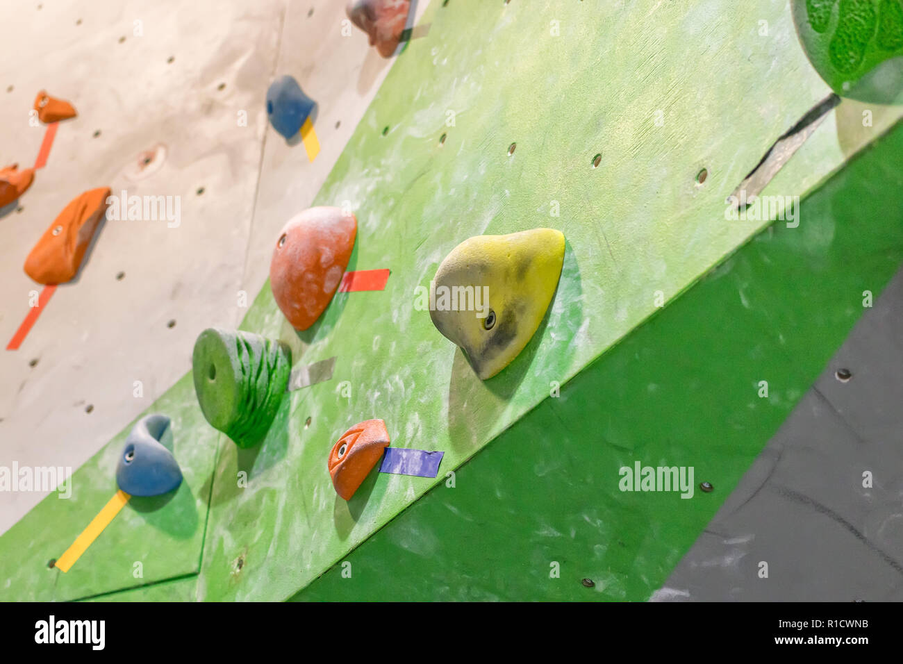 Climbing wall in the boulder hall with colored hooks Stock Photo - Alamy