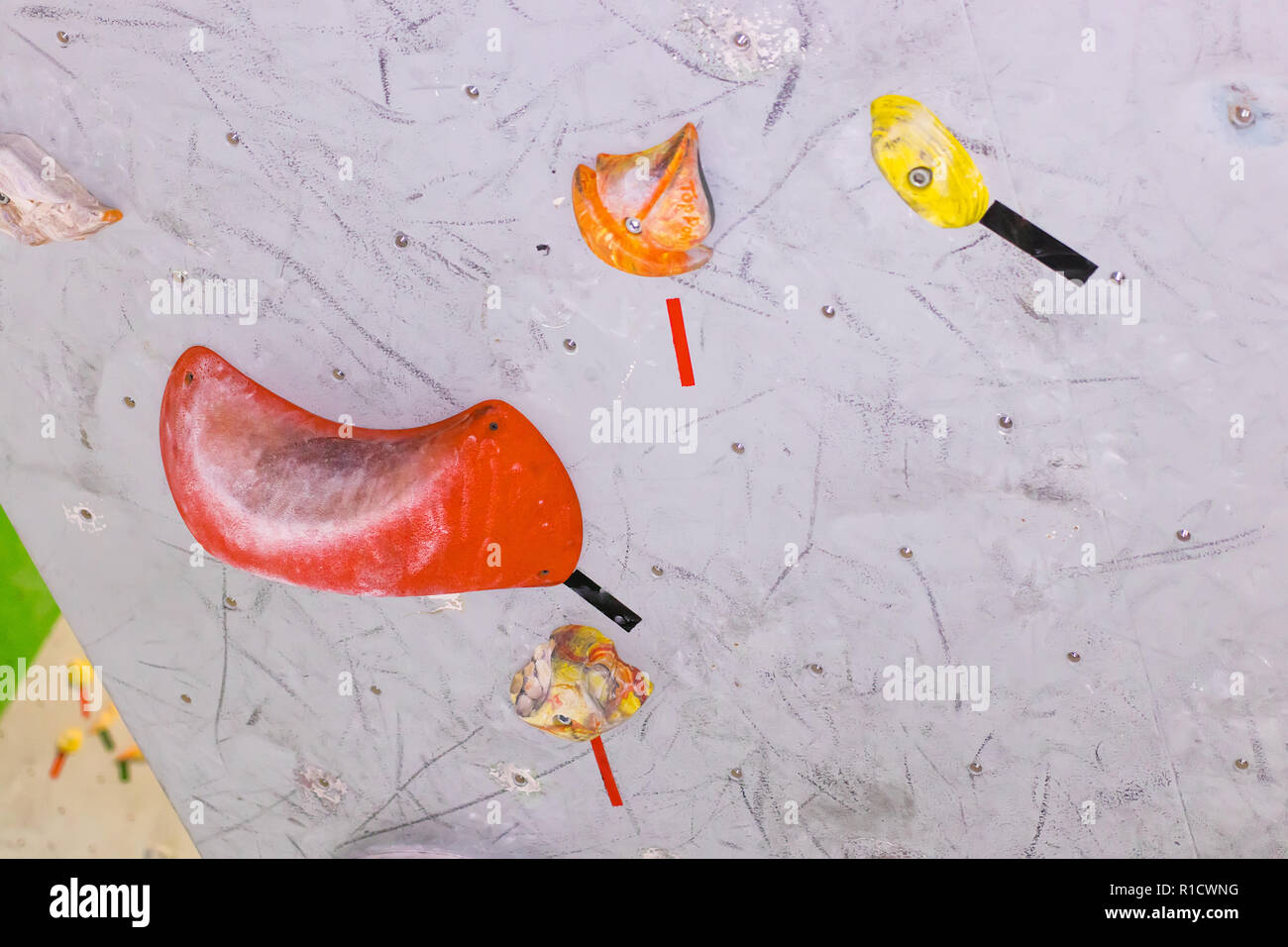 Climbing wall in the boulder hall with colored hooks Stock Photo - Alamy