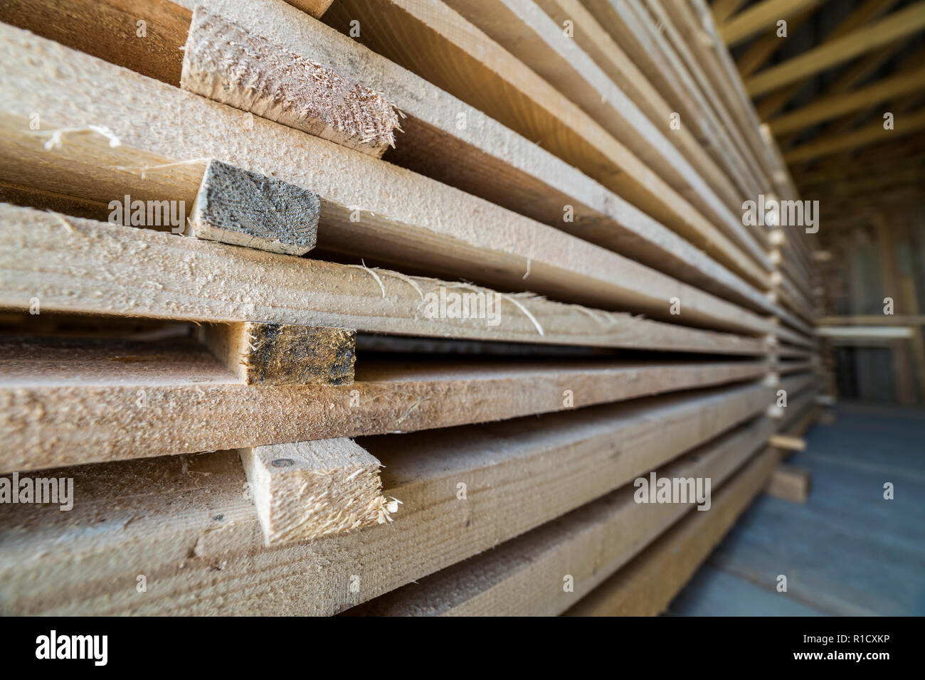 Perspective view of neatly piled long stack of natural uneven rough ...